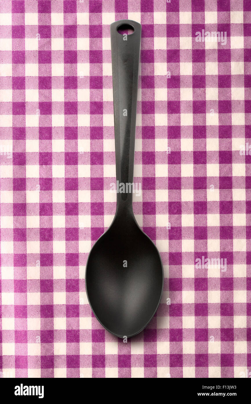 Black plastic kitchen spoon vertical in closeup Stock Photo - Alamy