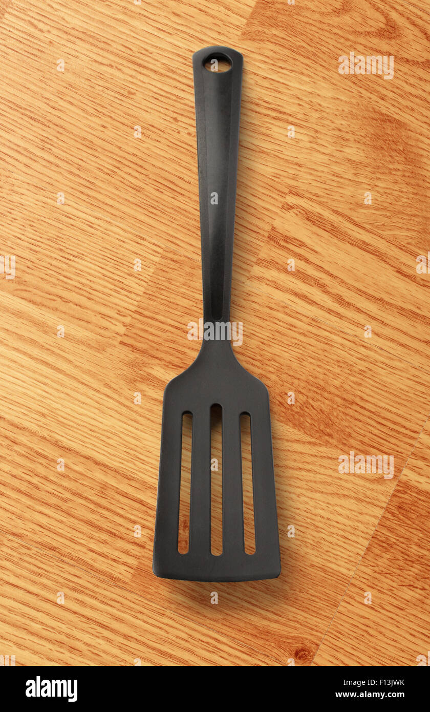 Black plastic kitchen spatula vertical in closeup Stock Photo - Alamy
