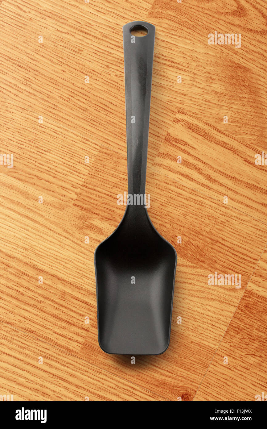 Black plastic kitchen spoon vertical in closeup Stock Photo - Alamy