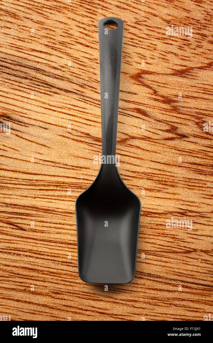 Black plastic kitchen spoon vertical in closeup Stock Photo - Alamy