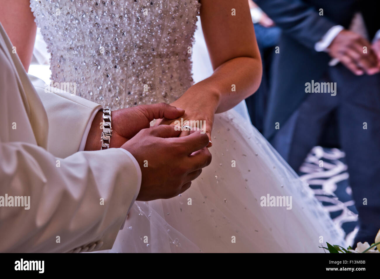 The groom placing the wedding ring on the brides finger during the ...