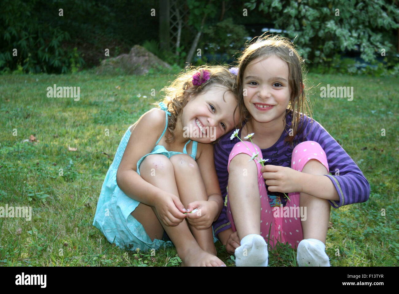 Happy sisters in the garden Stock Photo - Alamy