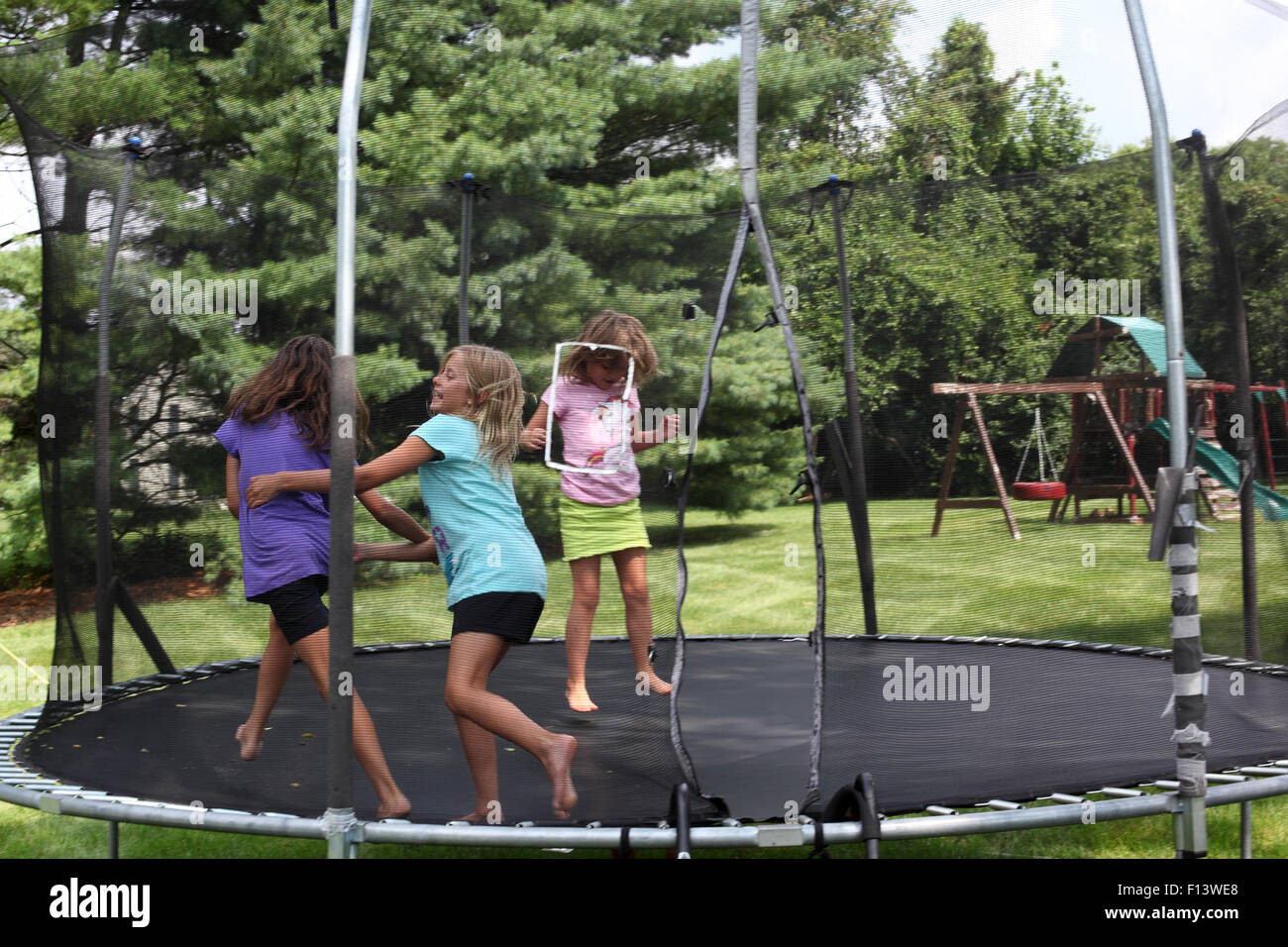 Three girls jumping on trampoline Stock Photo - Alamy