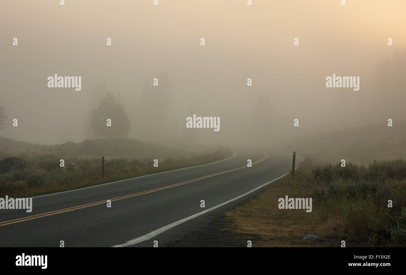 Winding road disappears into fog Stock Photo - Alamy