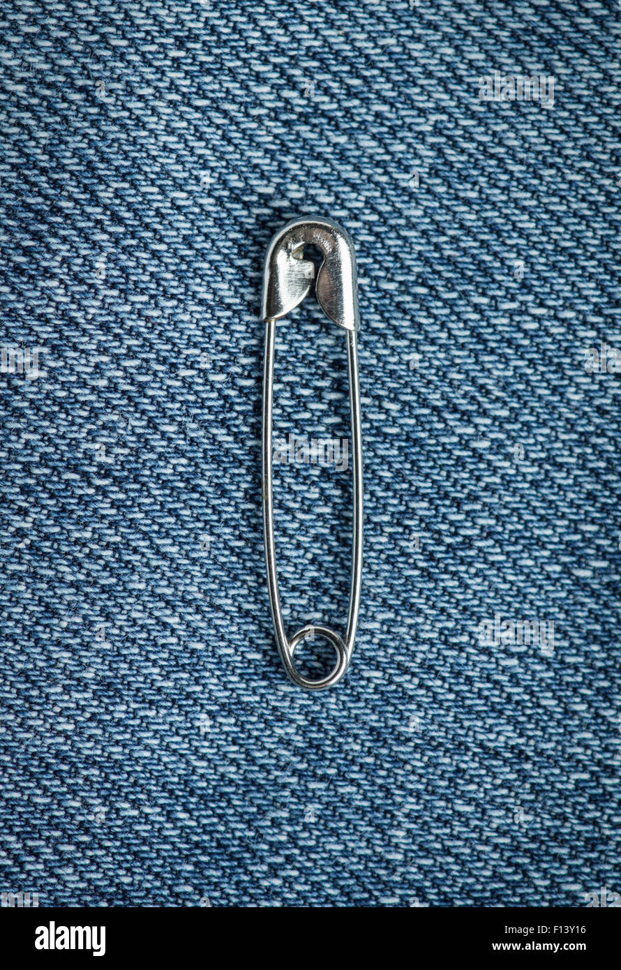 Safety pin on blue background closeup Stock Photo - Alamy
