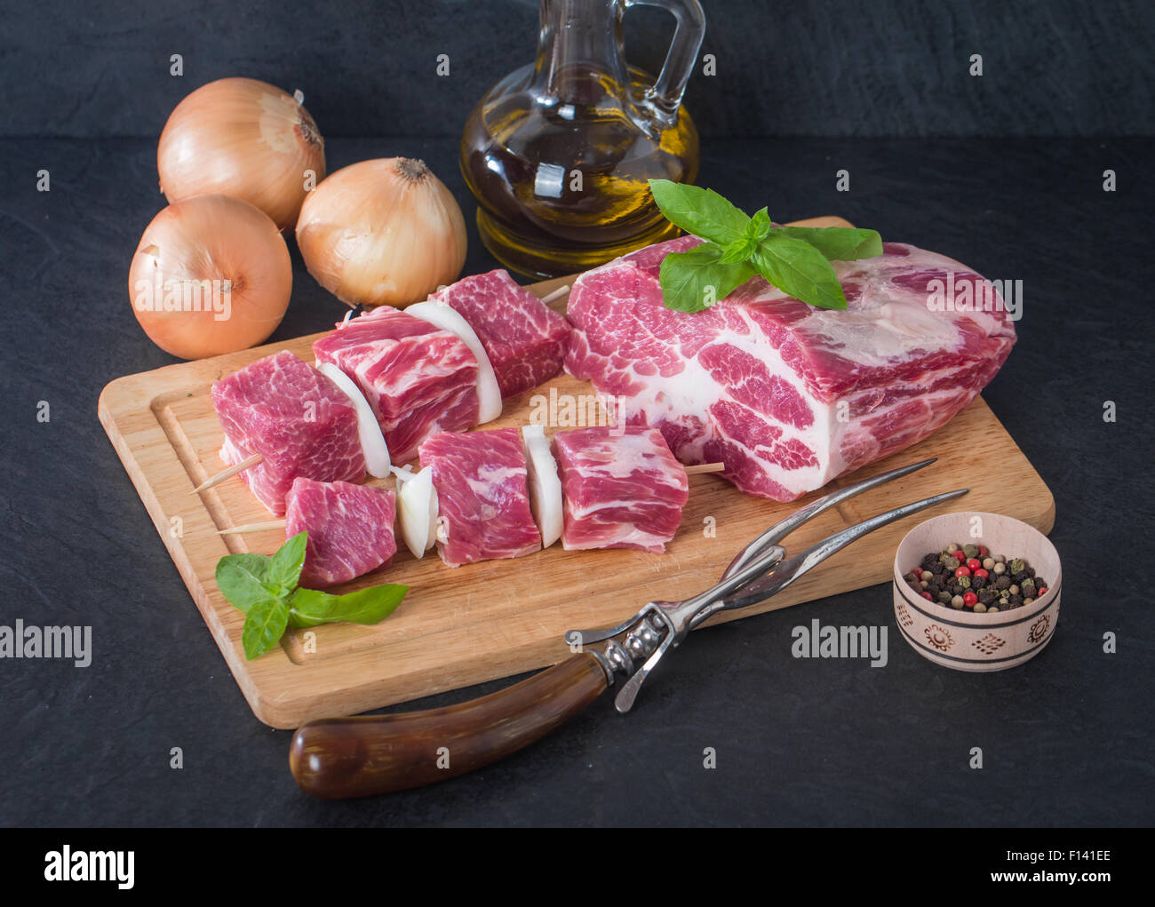 Raw pork meat cut into cubes ready for bbq (kebab) on black background ...