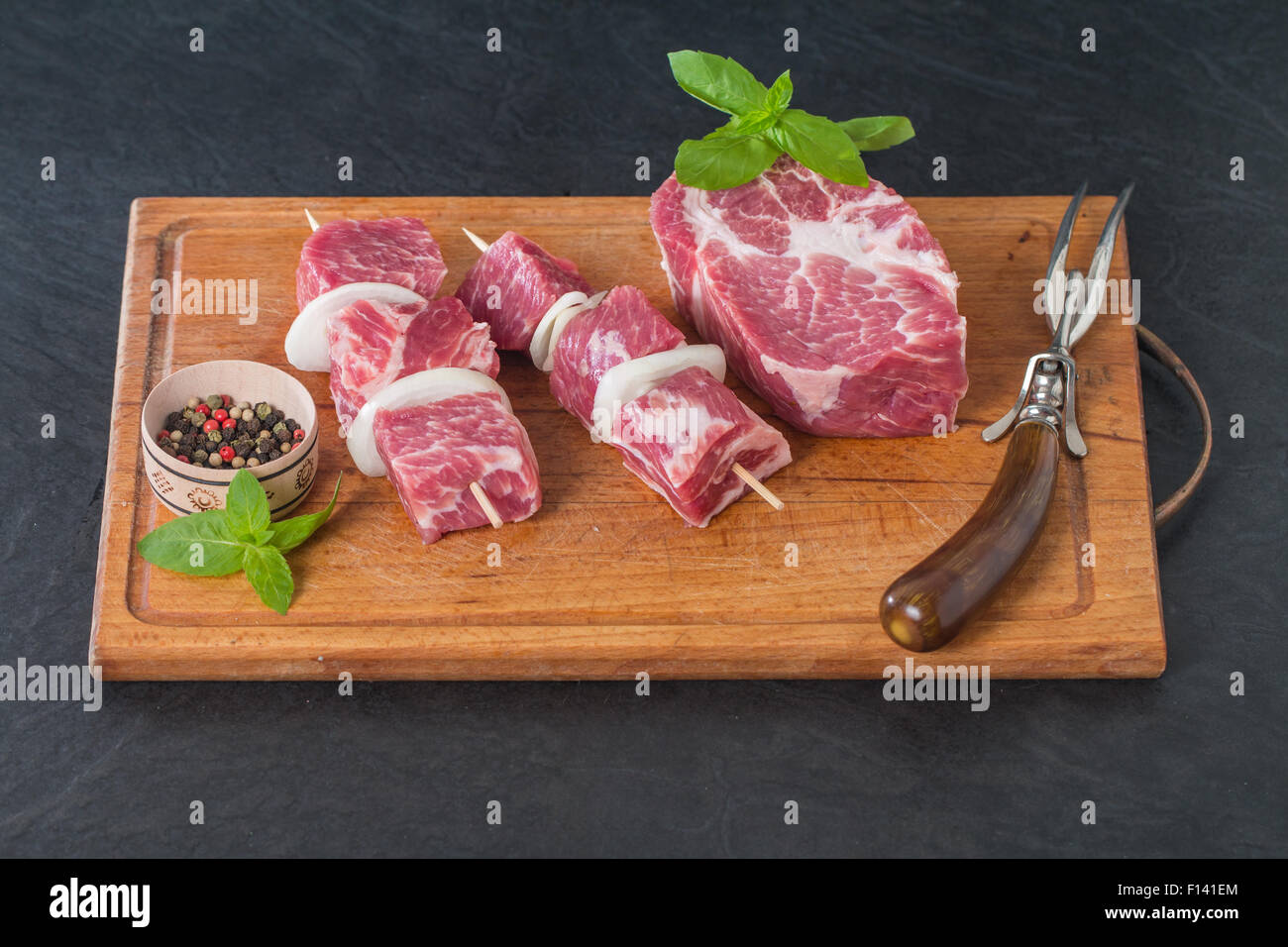 Raw pork meat cut into cubes ready for bbq (kebab) on black background ...