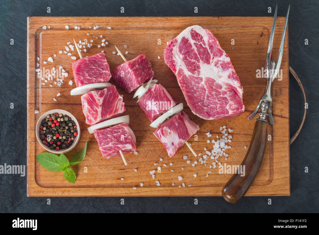 Raw pork meat cut into cubes ready for bbq (kebab) on black background ...