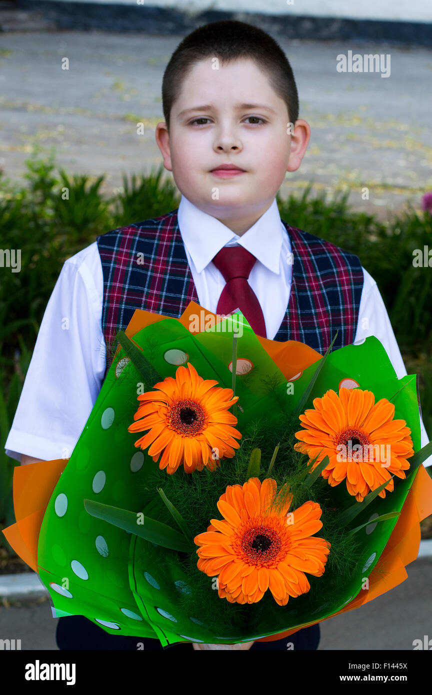 the beautiful school student with a bouquet of bright orange flowers ...