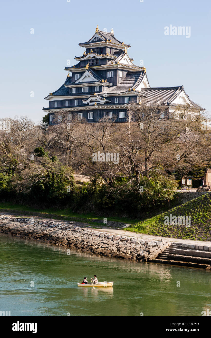 Okayama Japanese castle. Black boarded castle standing on top of river ...