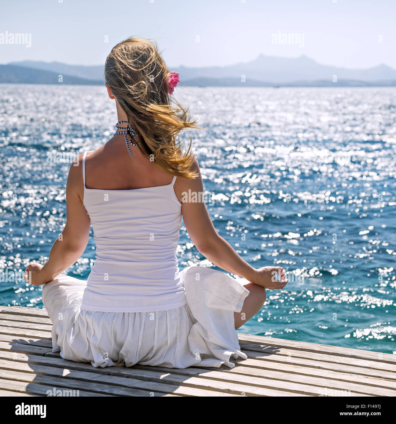 Woman meditating at the sea Stock Photo - Alamy