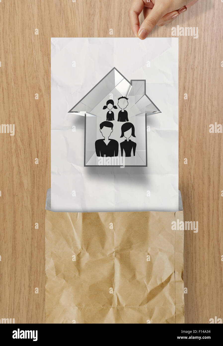 hand open crumpled paper to show hand draw family and house icon on ...