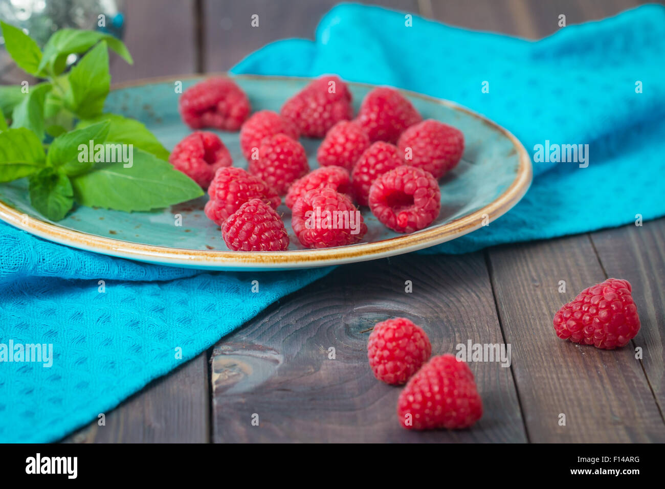 raspberries and mint leaves in a plate on wooden background Stock Photo ...