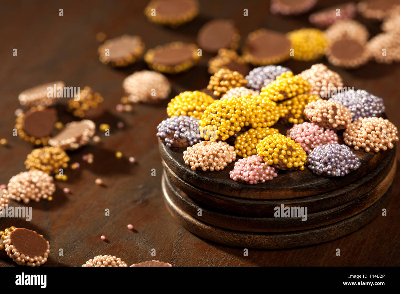 Colorful chocolate dragees placed in a wooden surface Stock Photo - Alamy