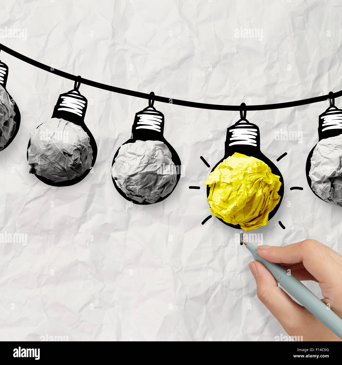 hand drawn light bulb on wire doodle with crumpled paper as leadership ...