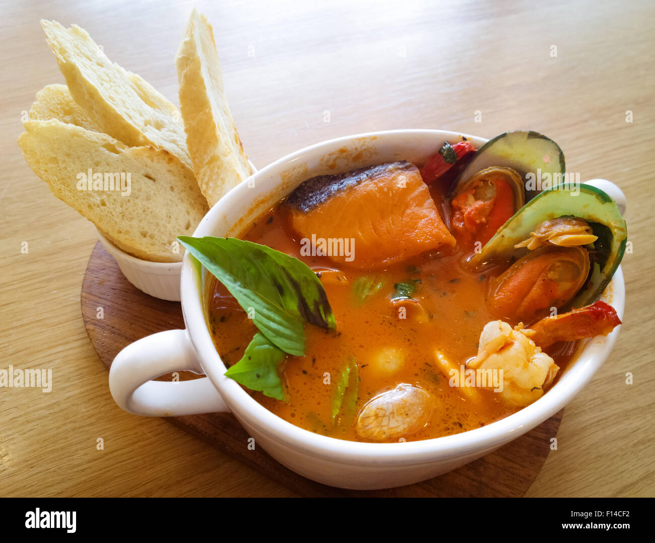 Delicious mediterranean seafood soup on wooden table Stock Photo - Alamy