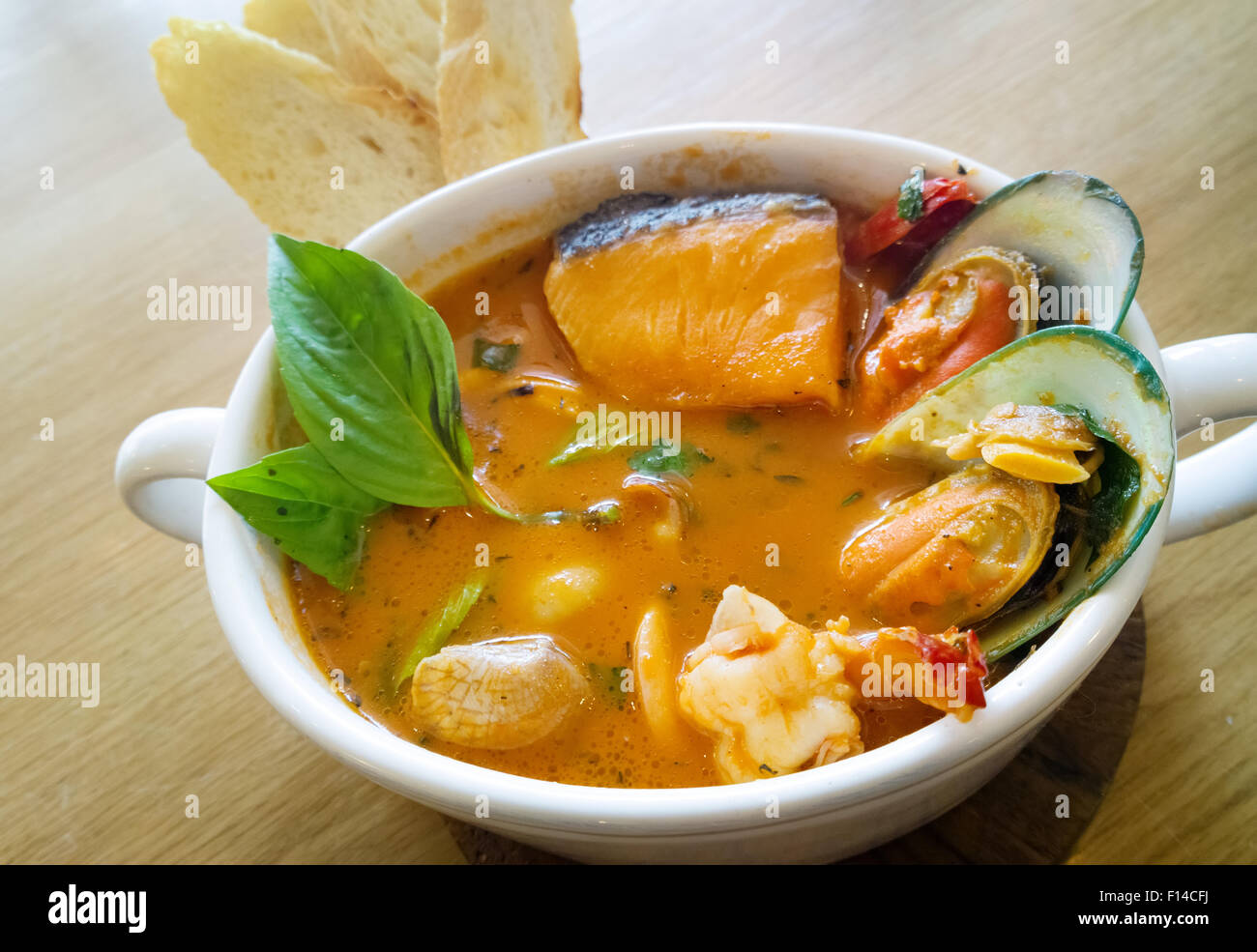 Delicious mediterranean seafood soup on wooden table Stock Photo - Alamy