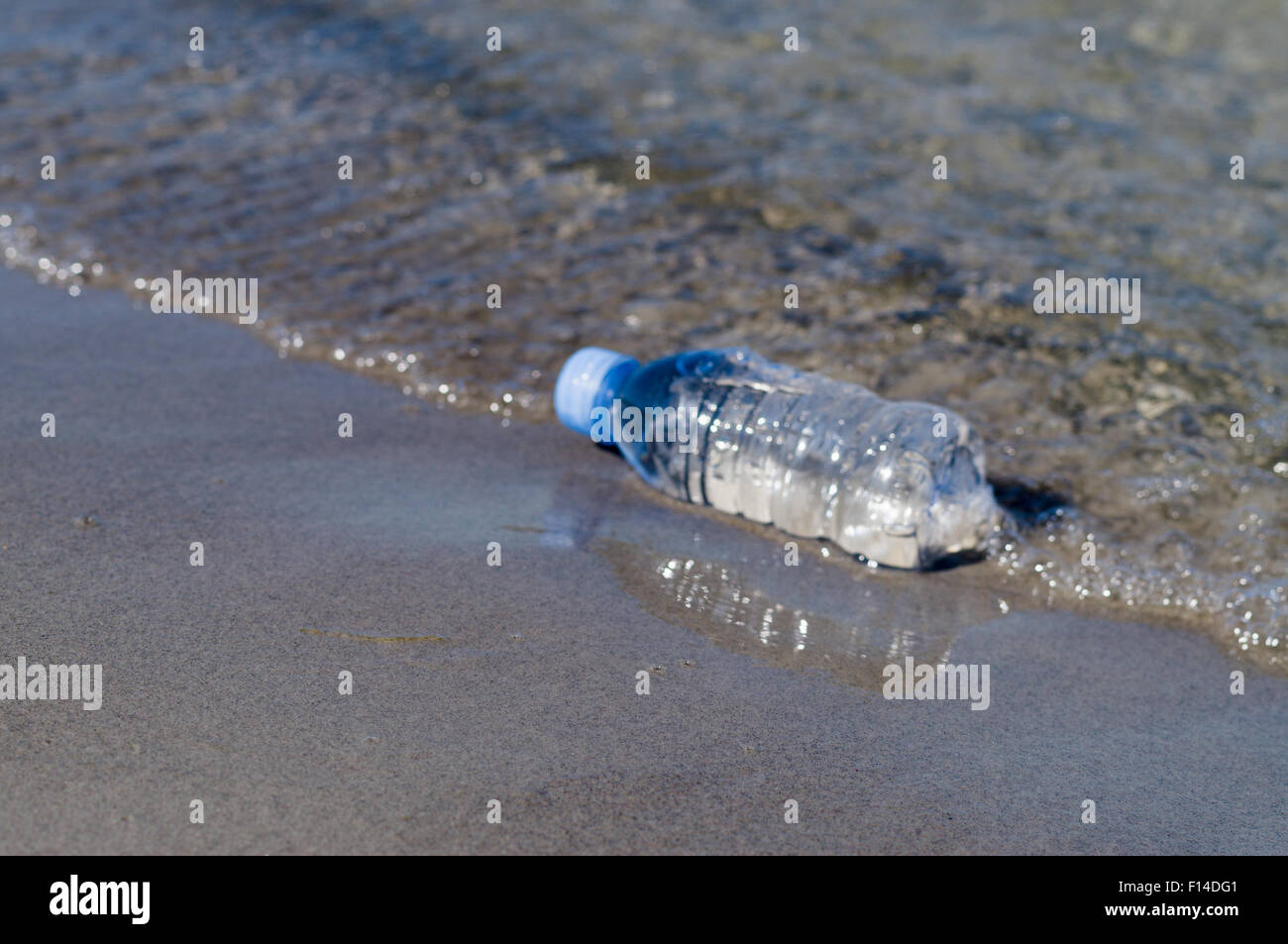 Blurred bottle of fresh water on the seashore, drinking water concept ...