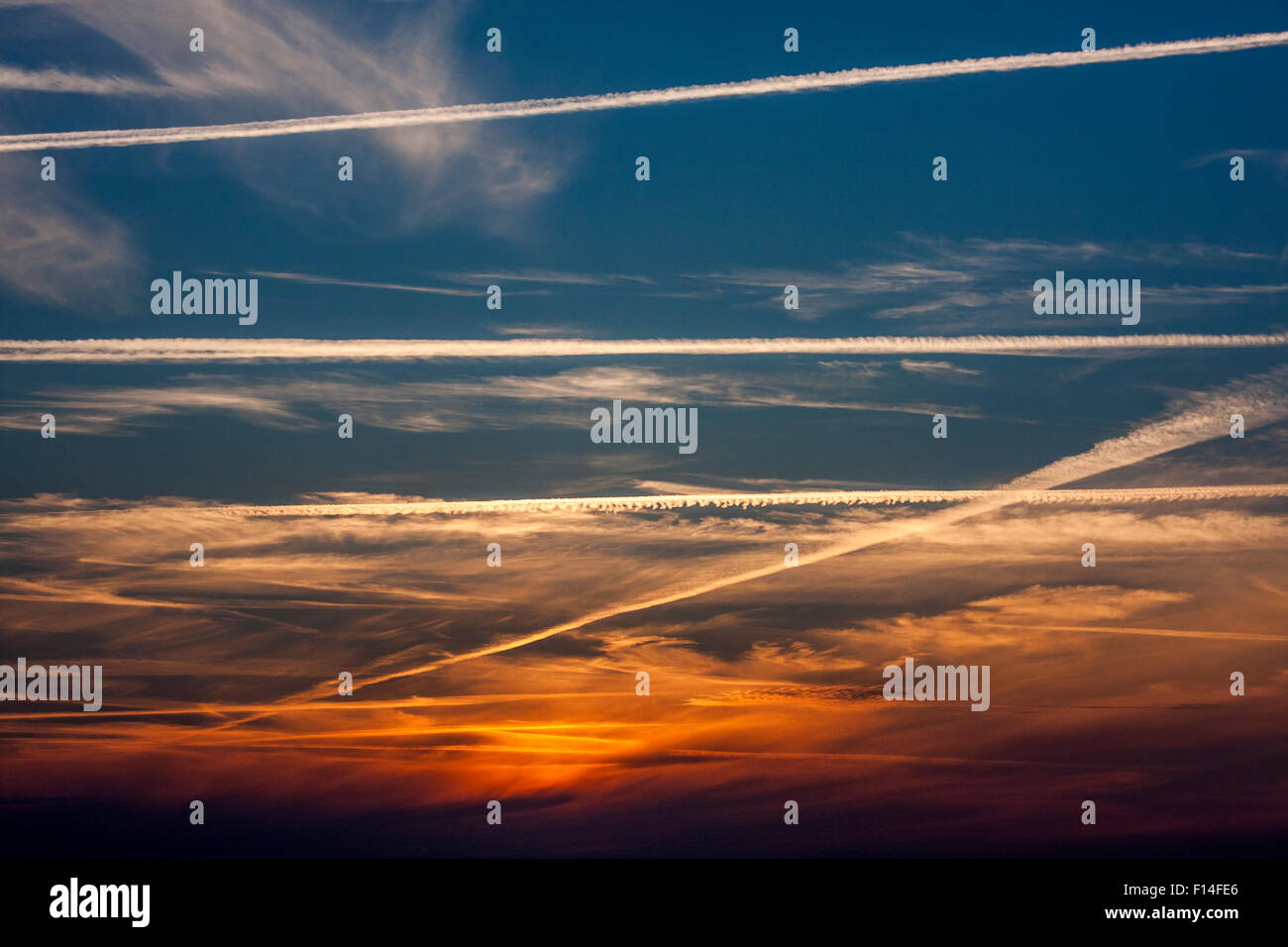Sunset with condensation trail of an airplane hi-res stock photography ...