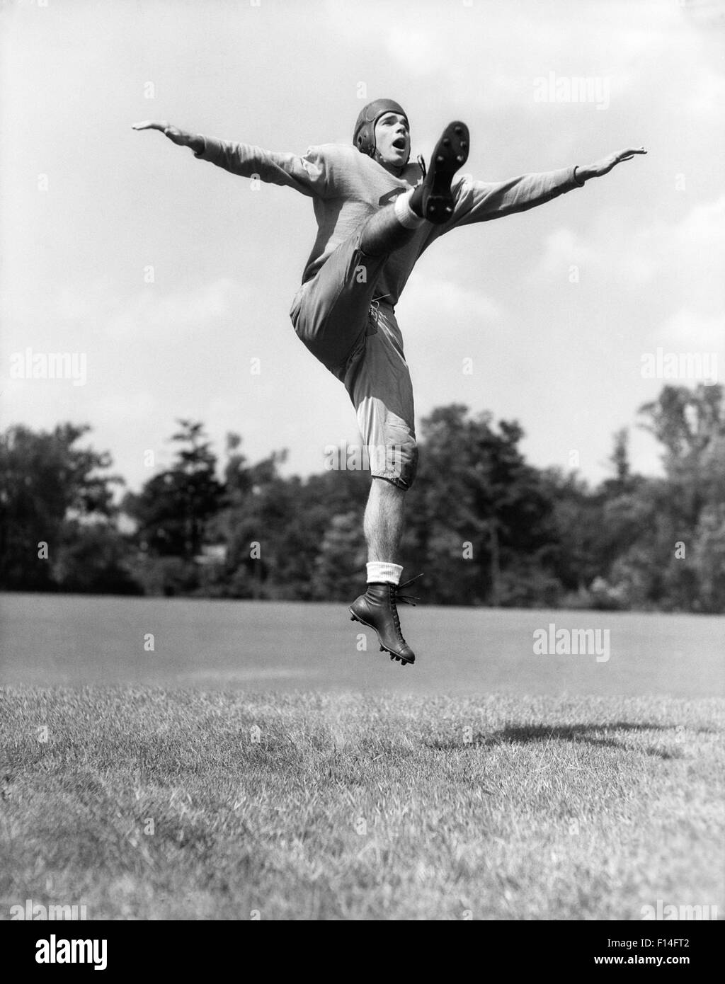 1930s HIGH SCHOOL OR COLLEGE FOOTBALL PLAYER PUNTING THE BALL Stock ...