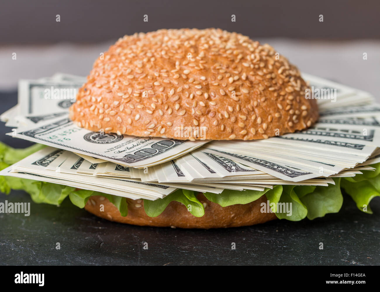 Hamburger with dollar bank notes on black background Stock Photo - Alamy