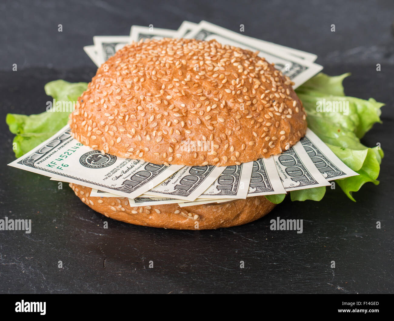 Hamburger with dollar bank notes on black background Stock Photo - Alamy