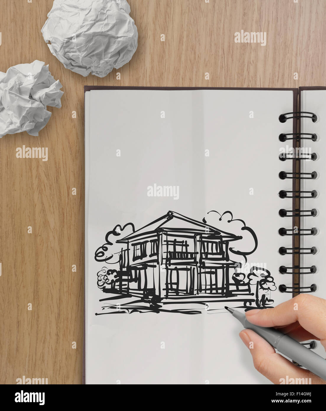 hand drawing house on wrinkled paper with wooden table as concept Stock ...