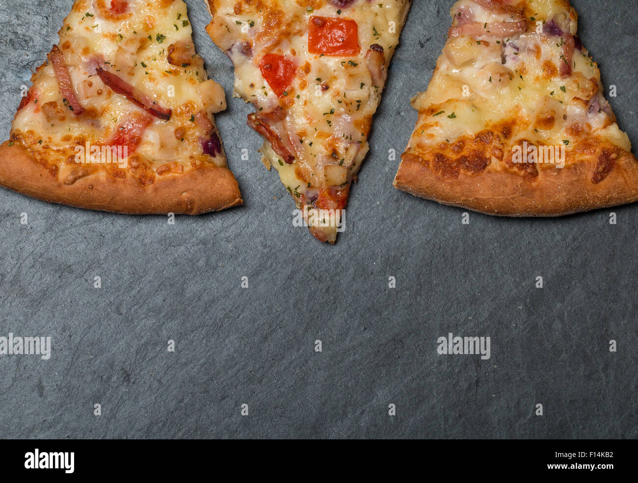 Fresh tasty pizza slices on black background, top view Stock Photo - Alamy