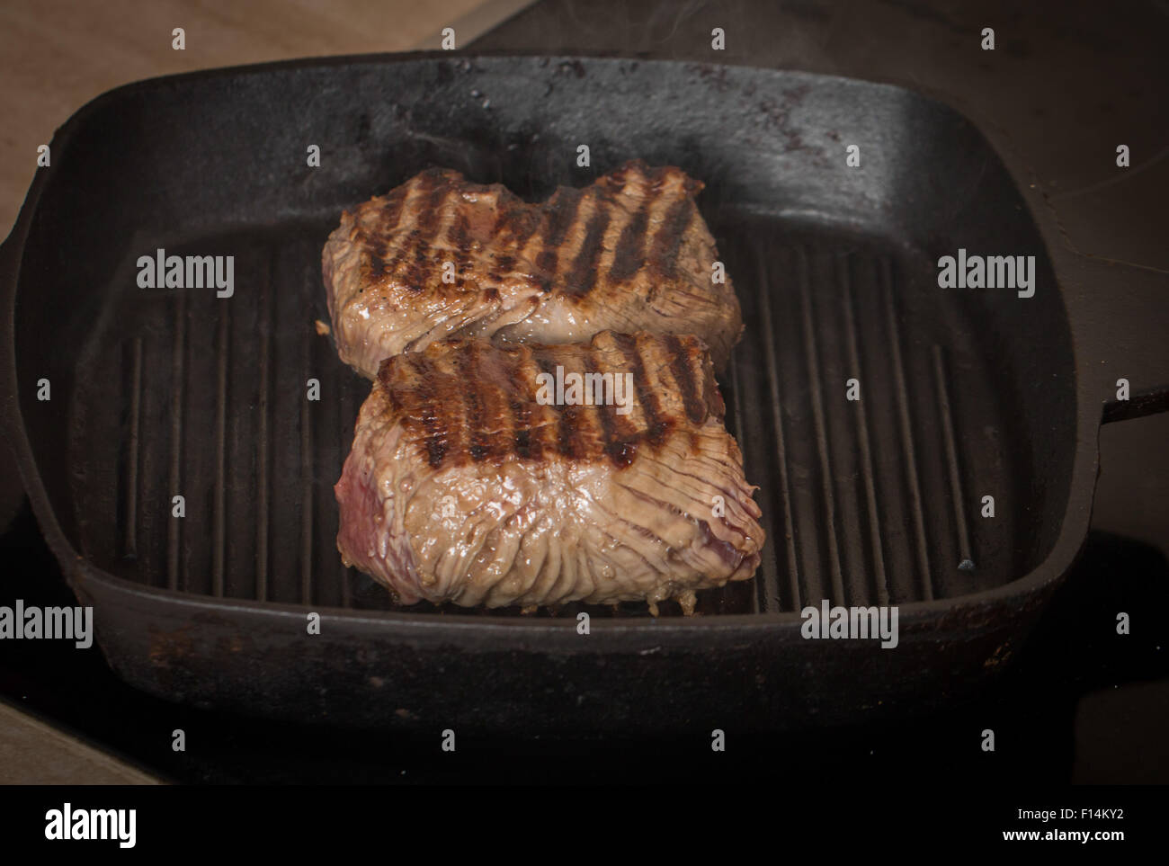 Hot Grilled beef steaks are cooking on grill pan Stock Photo - Alamy