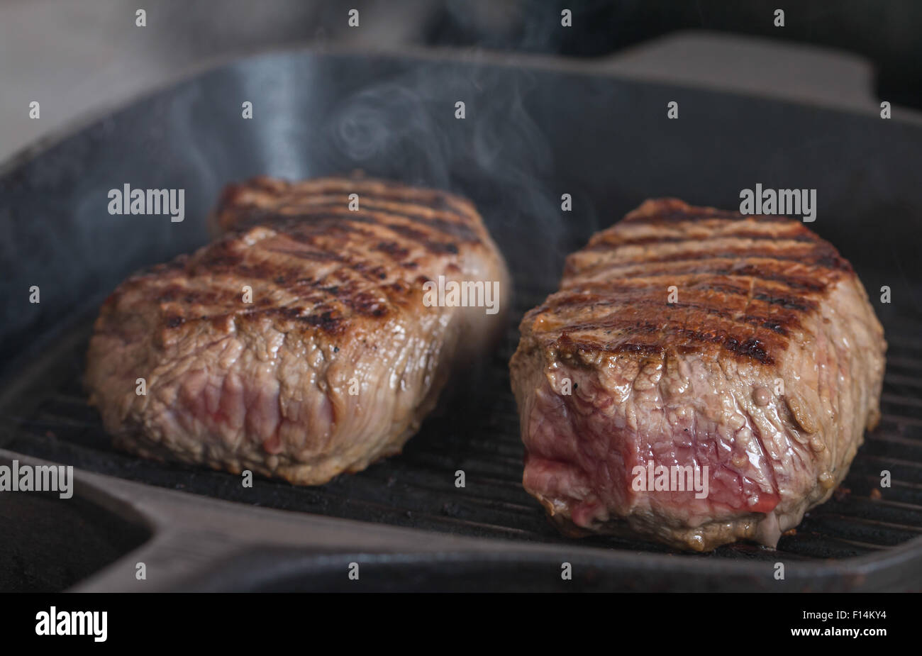 Hot Grilled beef steaks are cooking on grill pan Stock Photo - Alamy