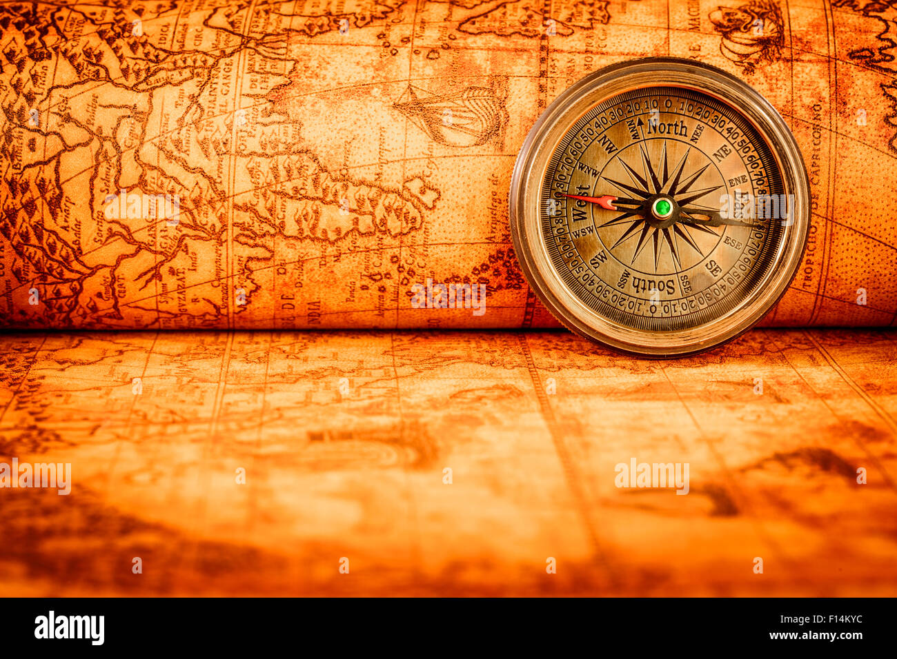 Vintage still life. Vintage compass lies on an ancient world map in ...