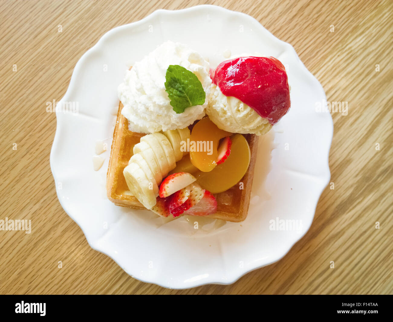 Waffle with fruits on wooden table Stock Photo - Alamy