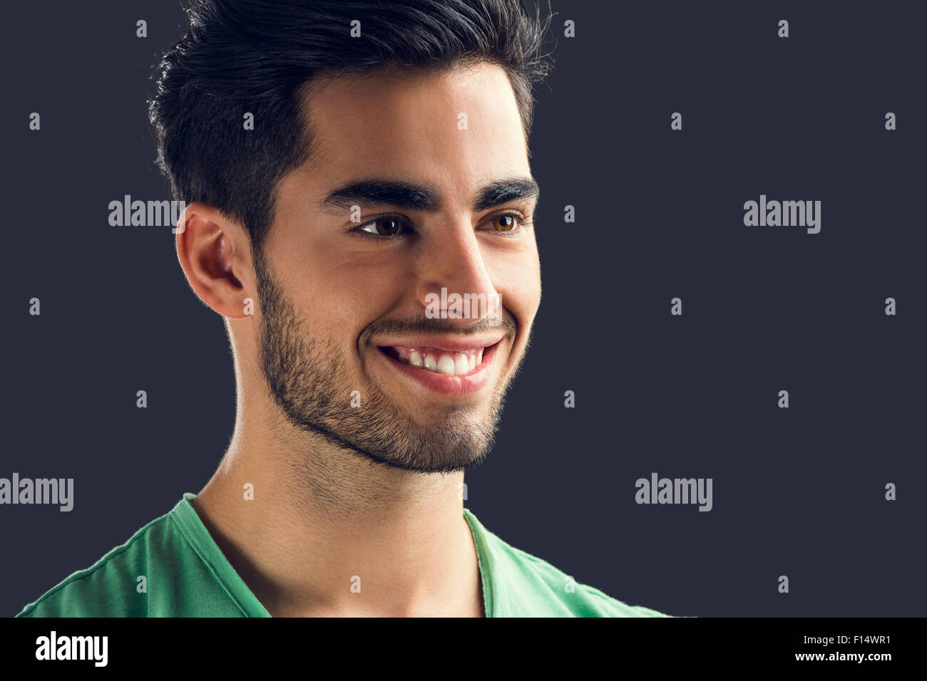 Portrait of handsome young man smiling, isolated on gray background ...