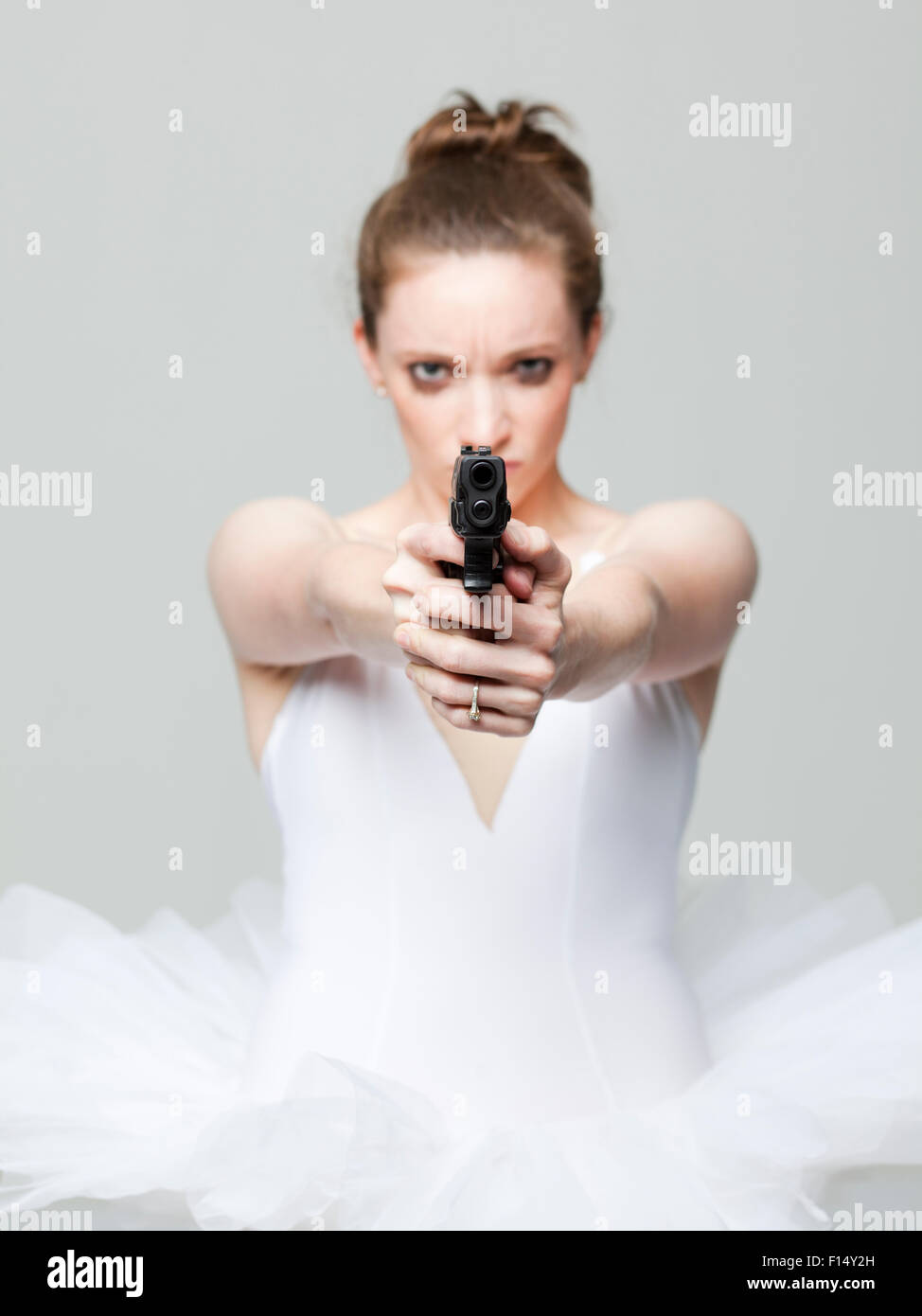 Studio shot of ballet dancer holding gun Stock Photo - Alamy