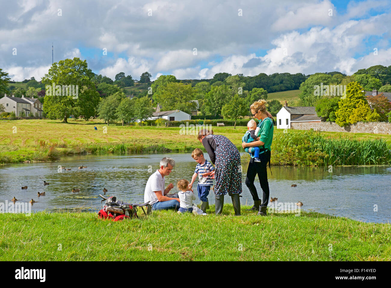 Family at the duckpond in the village of Caldbeck, Lake District ...