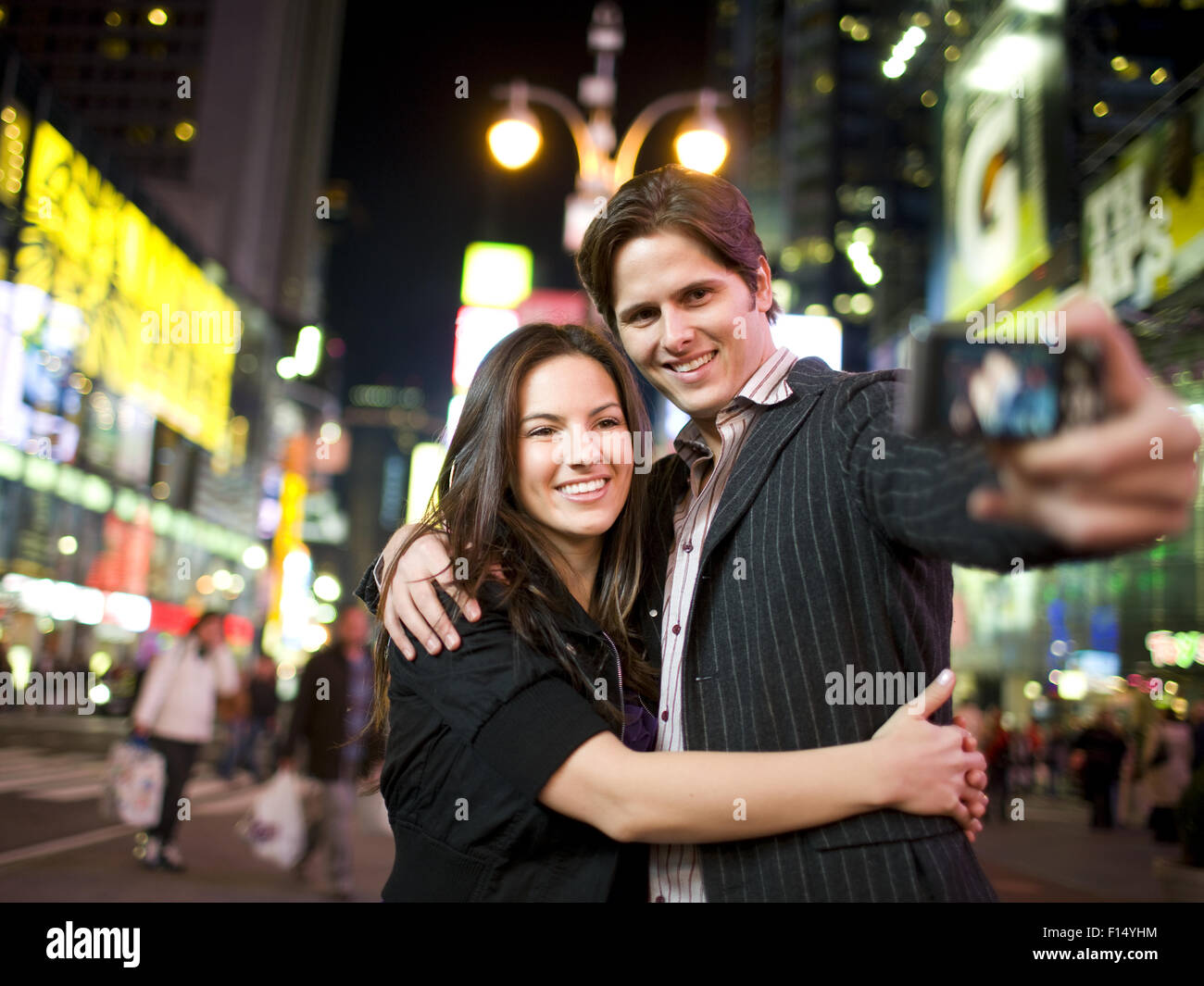 USA, New York City, Manhattan, Times Square, Young couple photographing ...