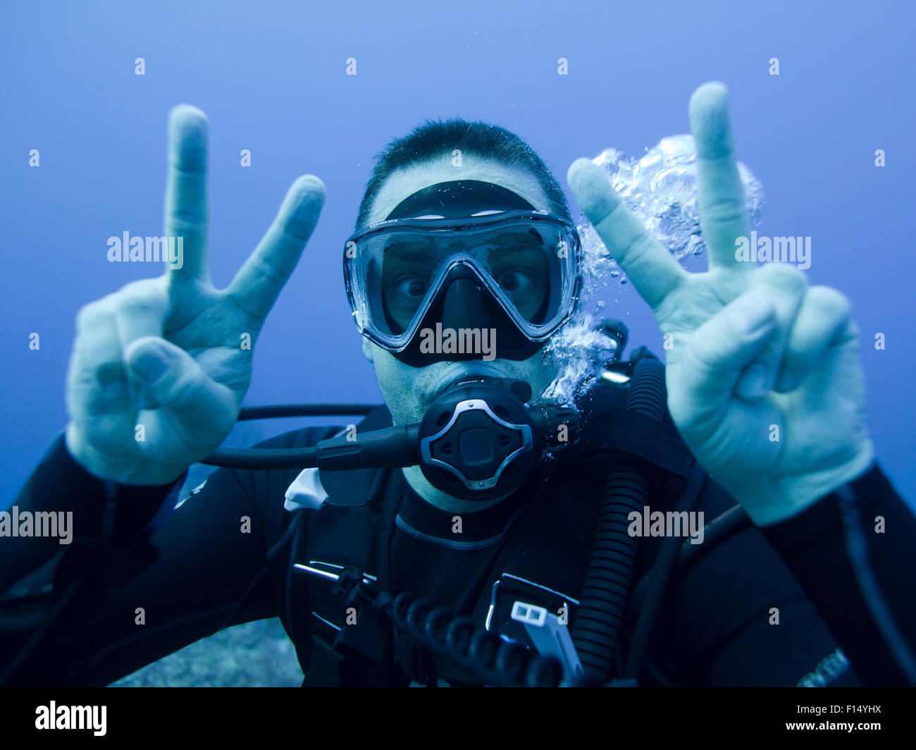 Person scuba diving underwater making peace sign Stock Photo - Alamy
