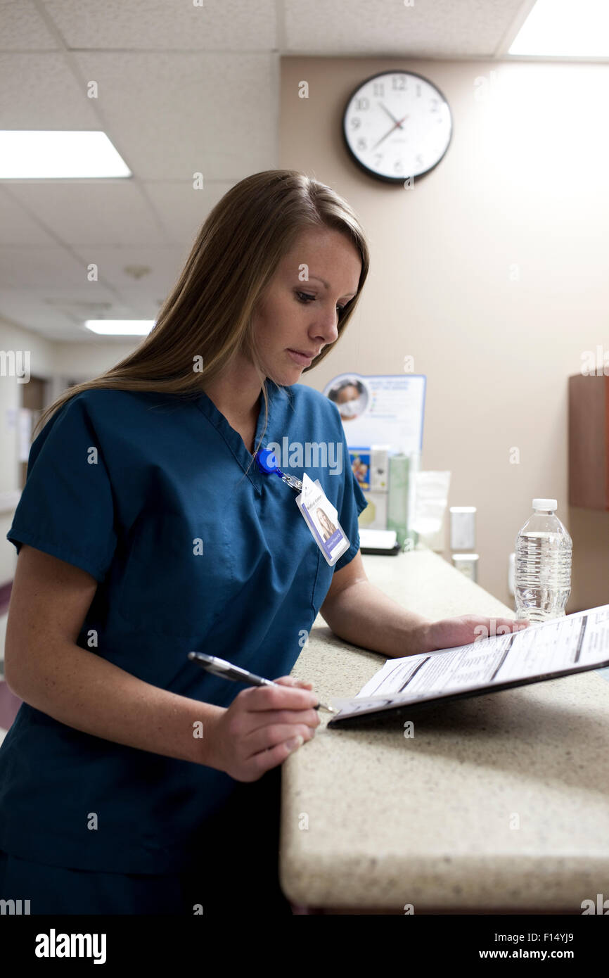 Young nurse filling documents hi-res stock photography and images - Alamy