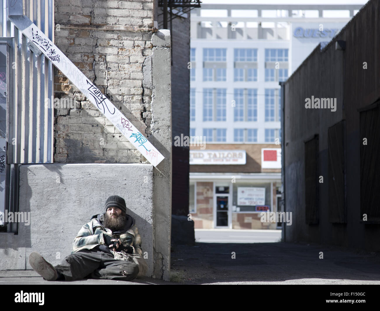 Homeless man sitting on city hi-res stock photography and images - Alamy