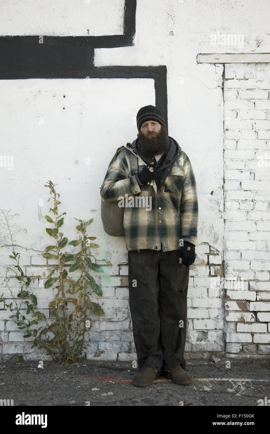 USA, Utah, Salt Lake City, Homeless man standing in front of brick wall ...