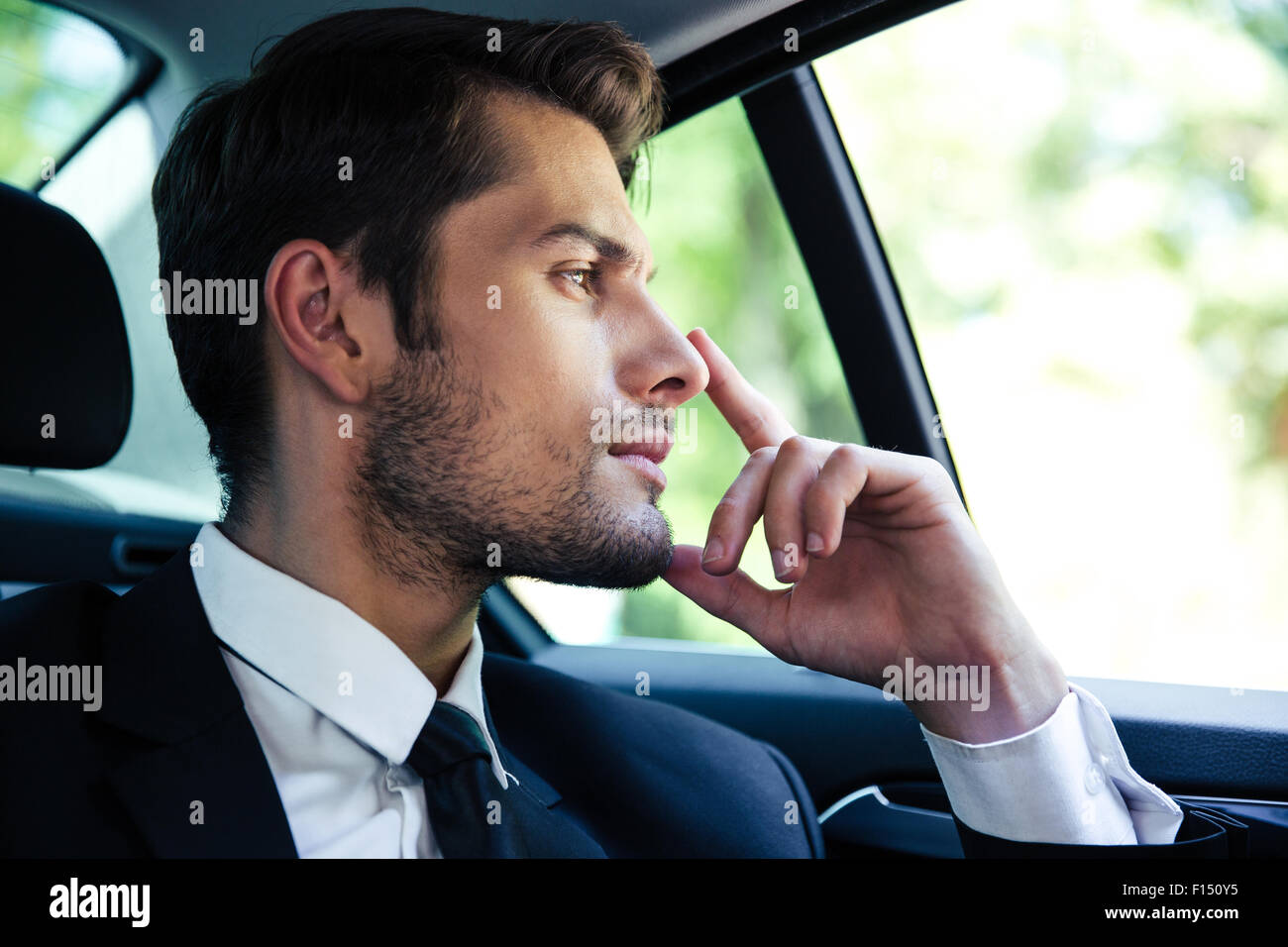 Thoughtful businessman riding in car Stock Photo - Alamy