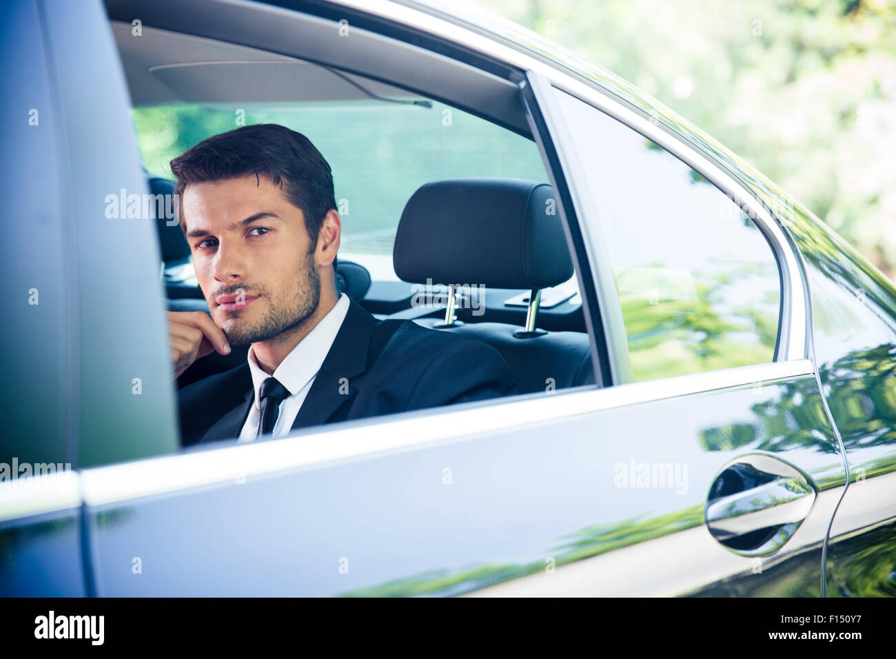 Confident businessman looking at window in car Stock Photo - Alamy
