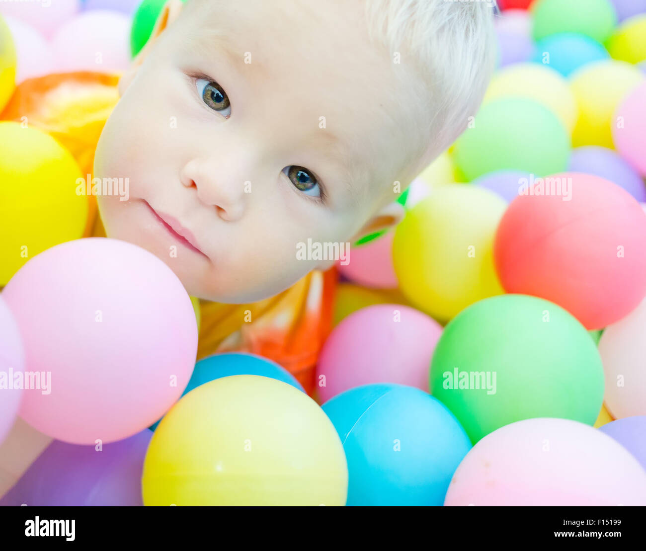 Cute kid boy playing with colorful balls Stock Photo - Alamy