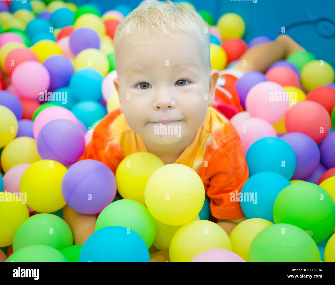 Cute kid boy playing with colorful balls Stock Photo - Alamy