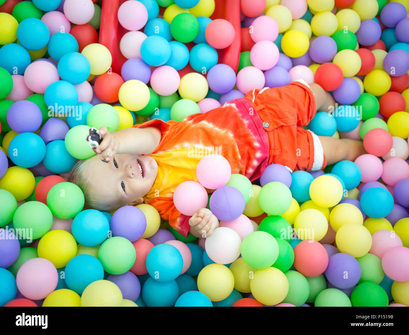 Cute kid boy playing with colorful balls Stock Photo - Alamy