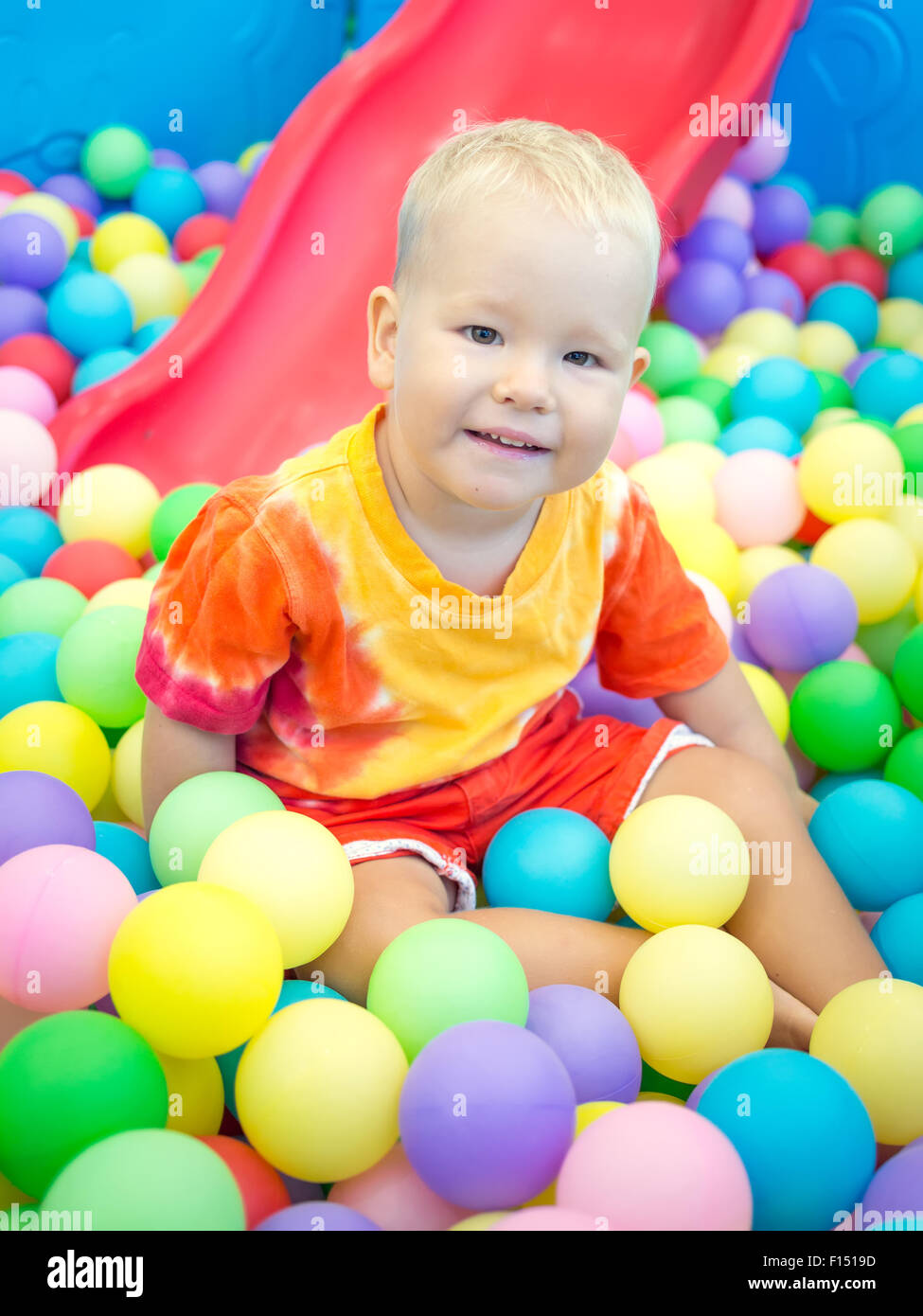 Cute kid boy playing with colorful balls Stock Photo - Alamy