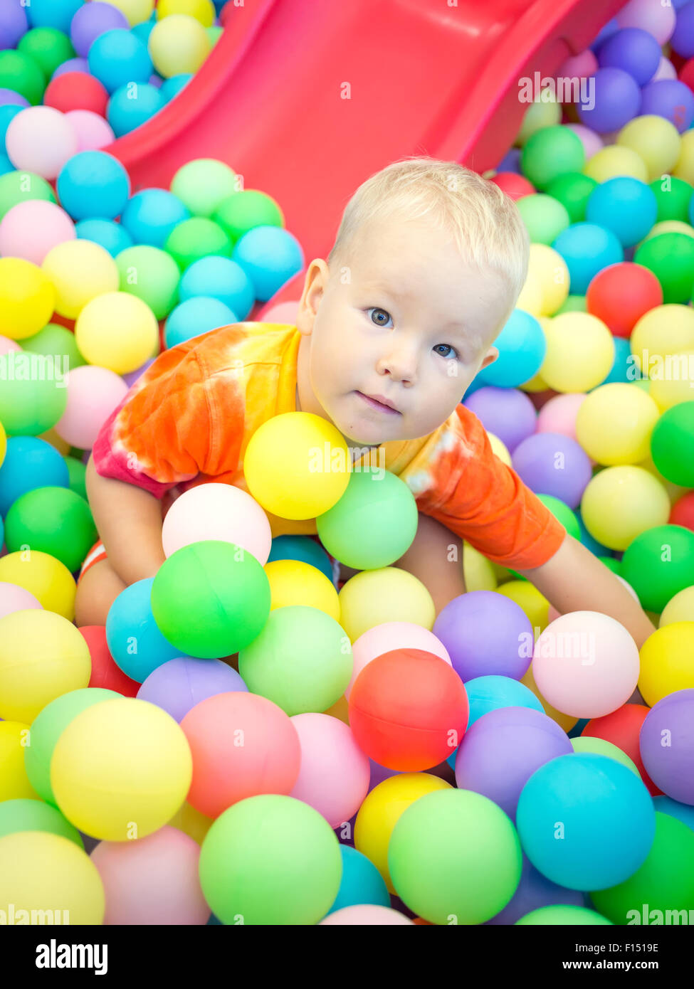 Cute kid boy playing with colorful balls Stock Photo - Alamy