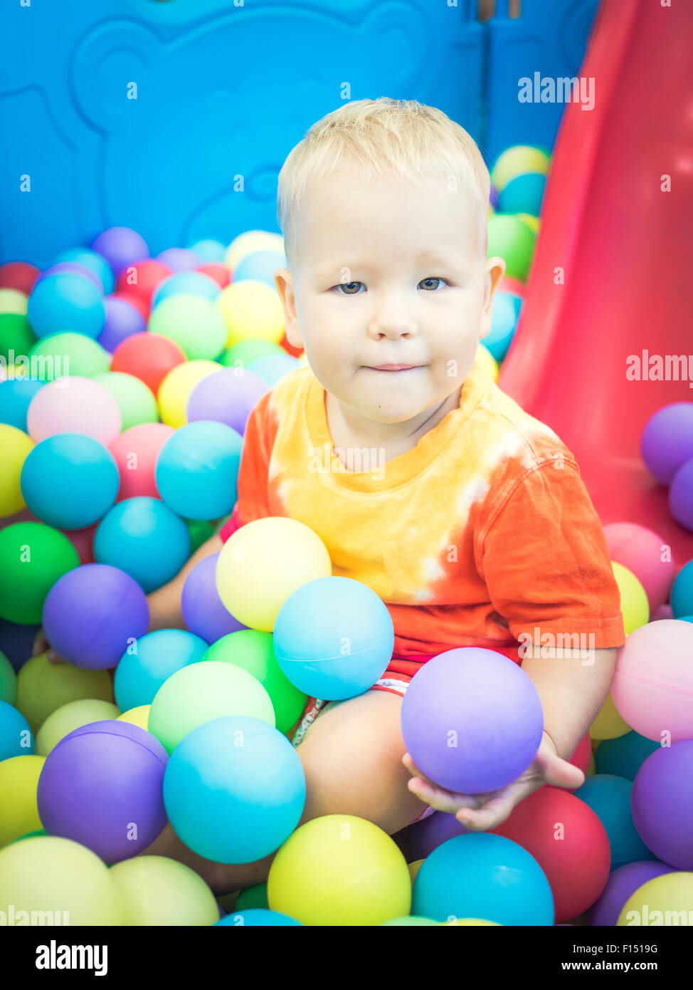 Cute kid boy playing with colorful balls Stock Photo - Alamy