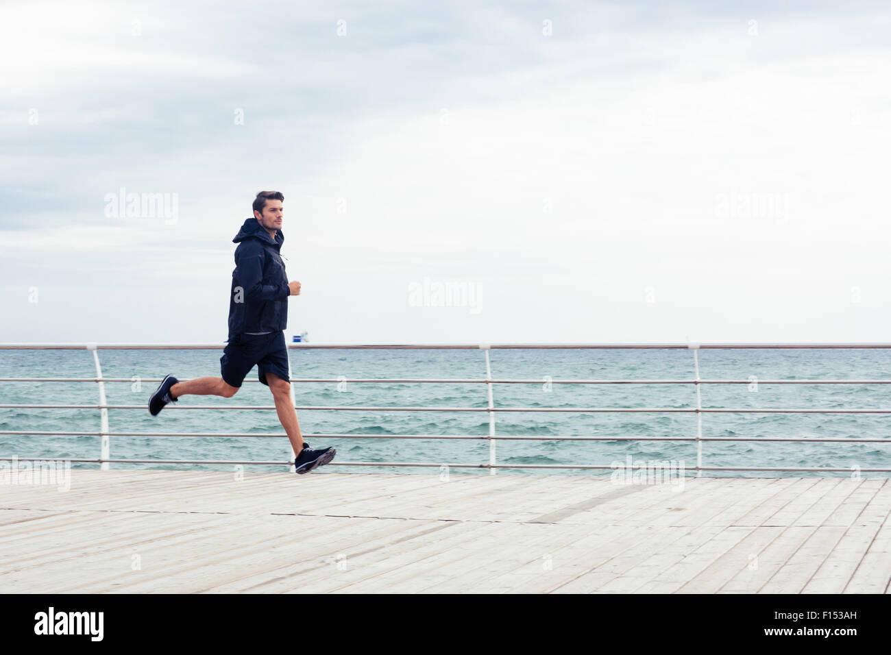 Sports man running near sea outdoors in the morning Stock Photo - Alamy
