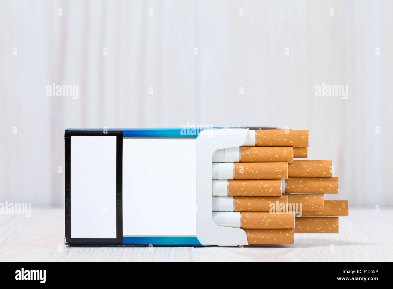 Open full pack of cigarettes on white wood background Stock Photo - Alamy